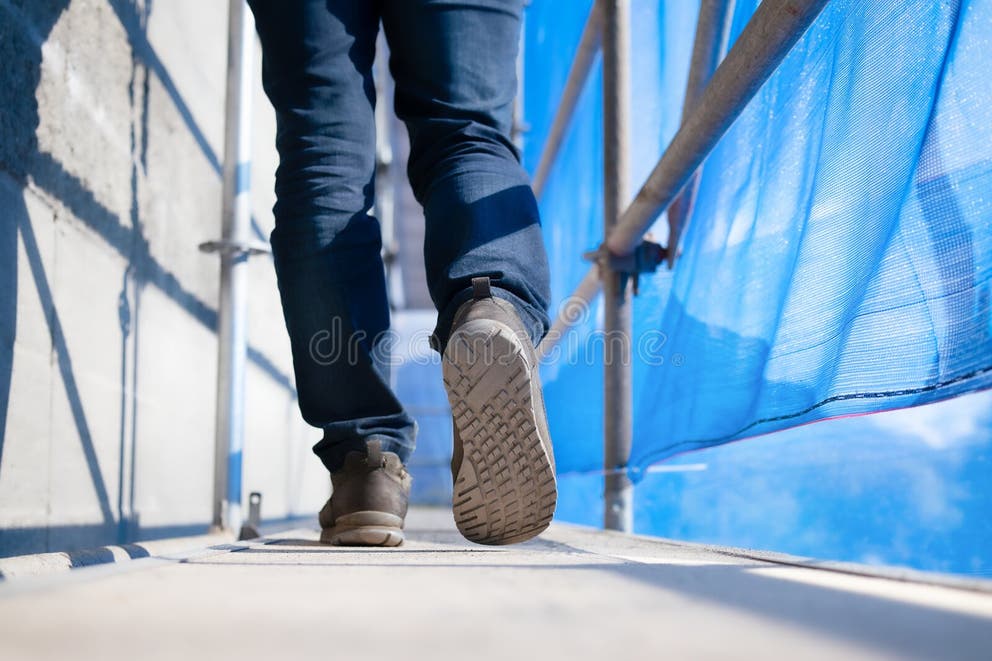 Back View of Engineer Walking Inside Scaffolding with Scaffold Netting ...