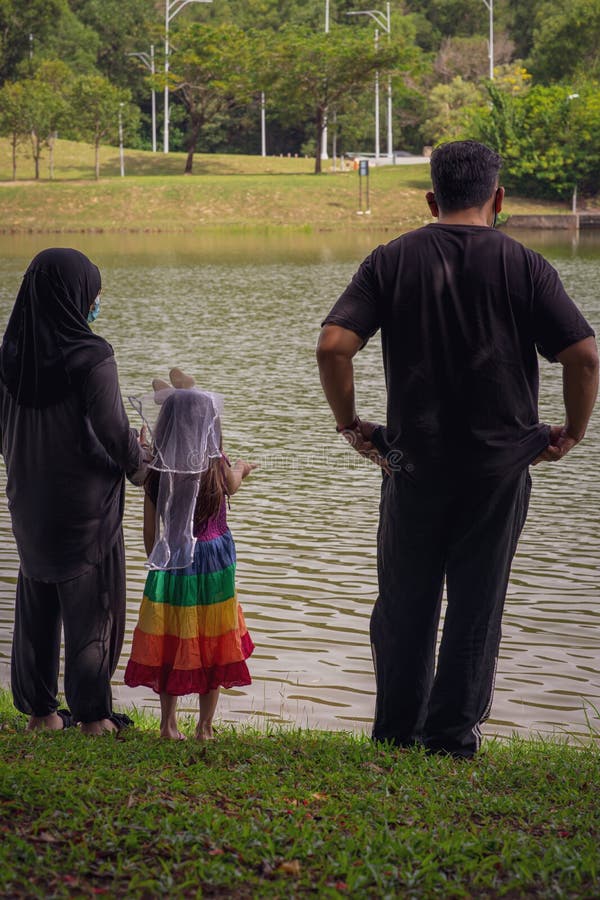 Back View of a Father and His Children Standing at the Lake`s Park ...