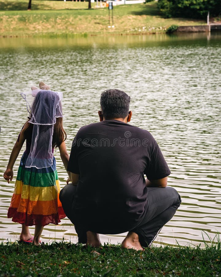 Back View of a Father and His Children Standing at the Lake`s Park ...
