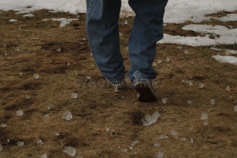 Back View of the Feet of a Man Walking on the Ground with Large Piece ...