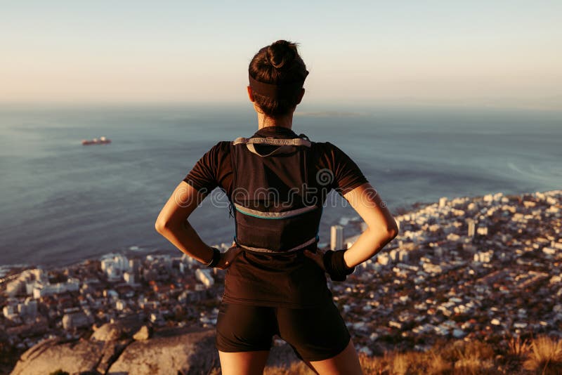 Back View of Female Hiker Standing on the Top of the Mountain Looking ...