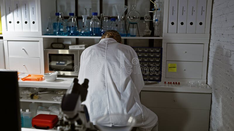 Back View of a Female Scientist in a Lab Coat Examining Research in a ...