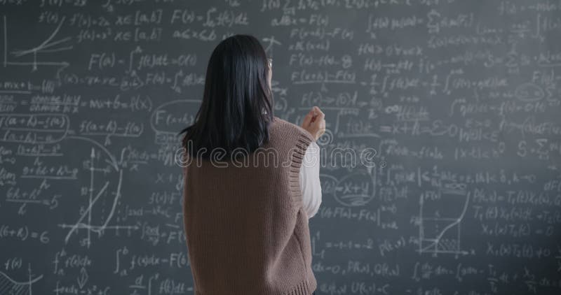 Back View of Female Scientist Looking at Chalkboard and Thinking about ...