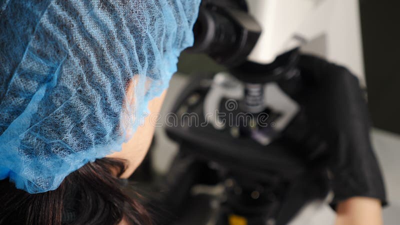 Back View of Female Scientist Using Microscope during Microbiological ...