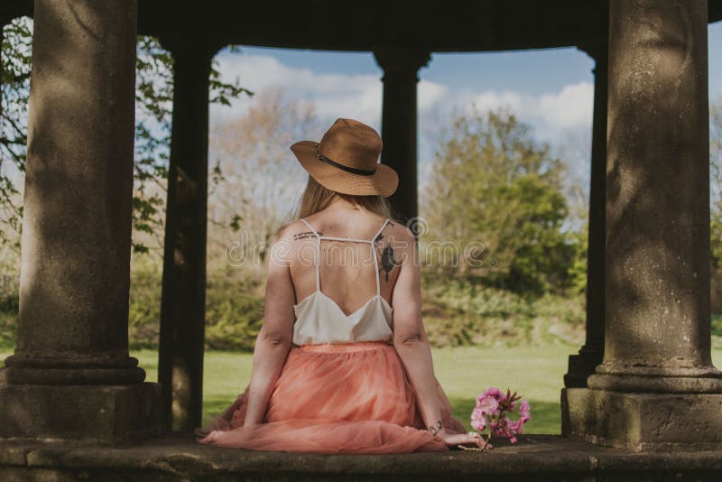 Back View of Female Sitting in Front of Park Surrounded by Dense Trees ...