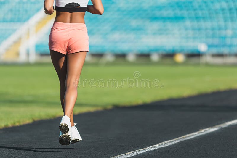 Back View of a Fit Sportswoman Running a Distance at the Stadium Stock ...