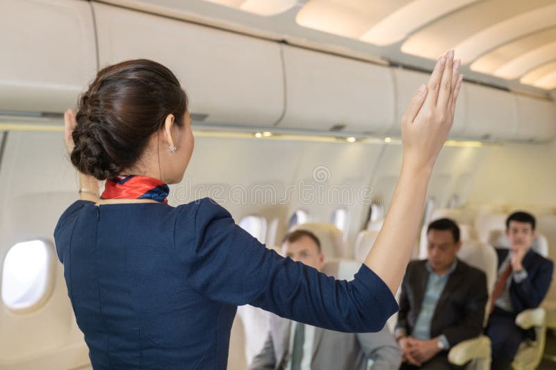 Back View of Flight Attendant Demonstrating Safety Instructions To ...