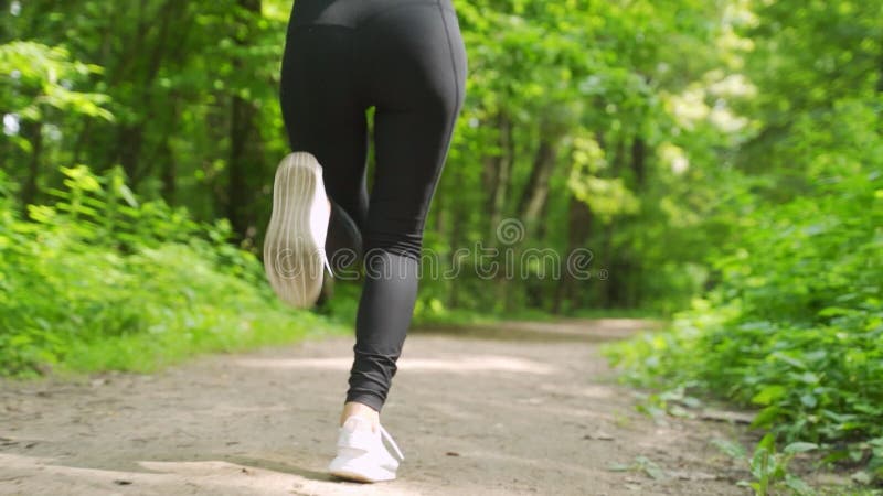 Back View of a Girl`s Feet Running through a Green Forest Stock Footage ...