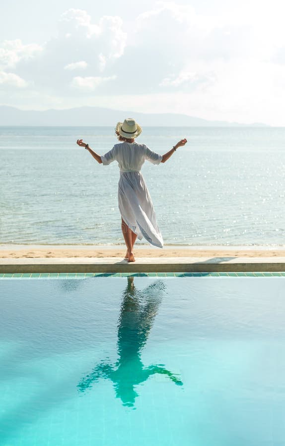 Back View of Girl Standing at Swimming Pool and Looking at the Ocean ...