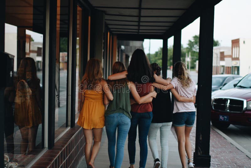 Back View of a Group of Female Friends Hugging and Walking Outdoors ...
