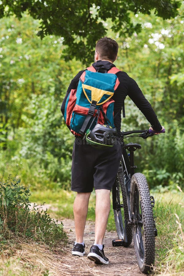Back View of Guy Backpacking with Bike in Forest Stock Image - Image of ...