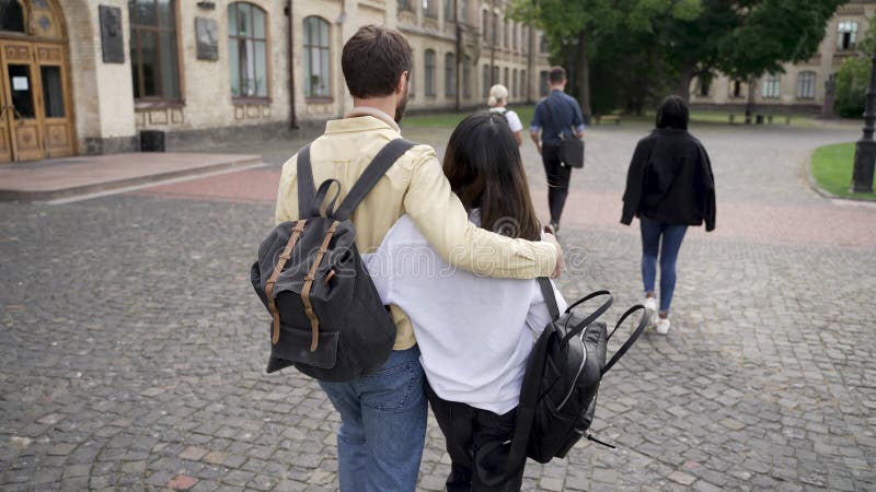 Hugging Couple of Students Walking through Park Stock Footage - Video ...