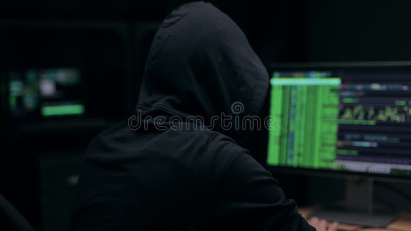 Back View of a Hooded Hacker Making Cyber Attack on Bank Network. Man ...