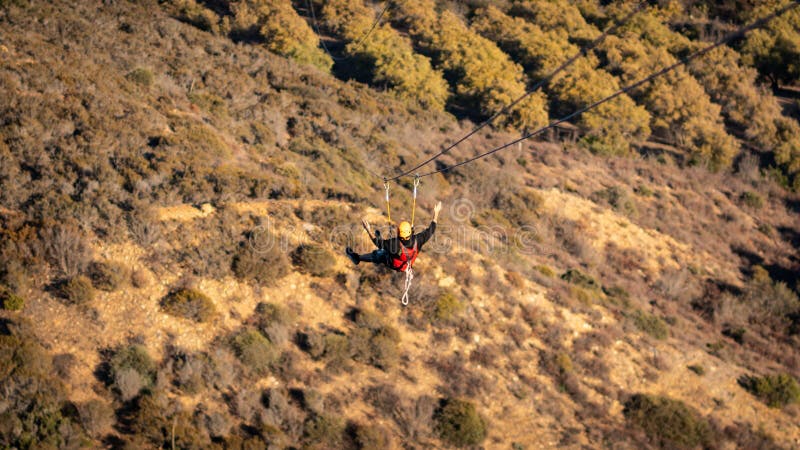 Back View of Human Flying with Zipline Over Greenery Mountains Stock ...