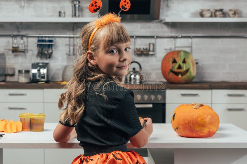 Back View of Kid in Halloween Costume at Tabletop with Pumpkins in ...