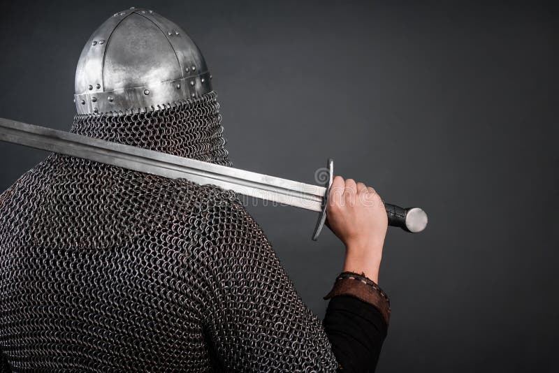 Back View of a Knight in Chain Mail and a Helmet with a Sword on His ...