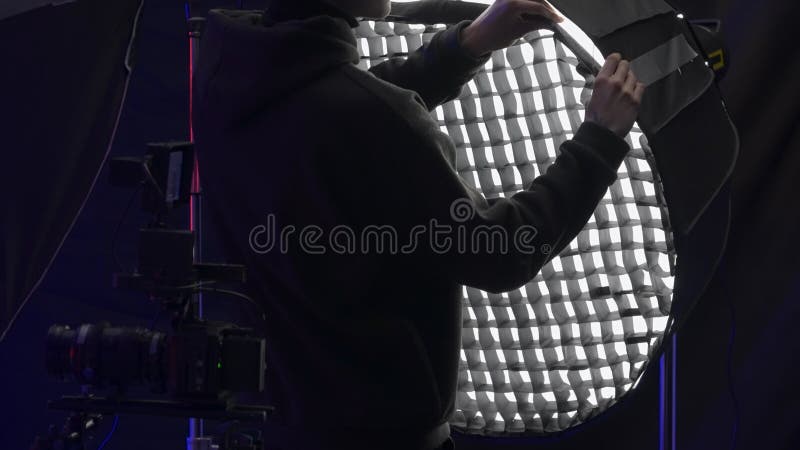 Back View of a Lighting Technician Putting a Net on a Spotlight To ...