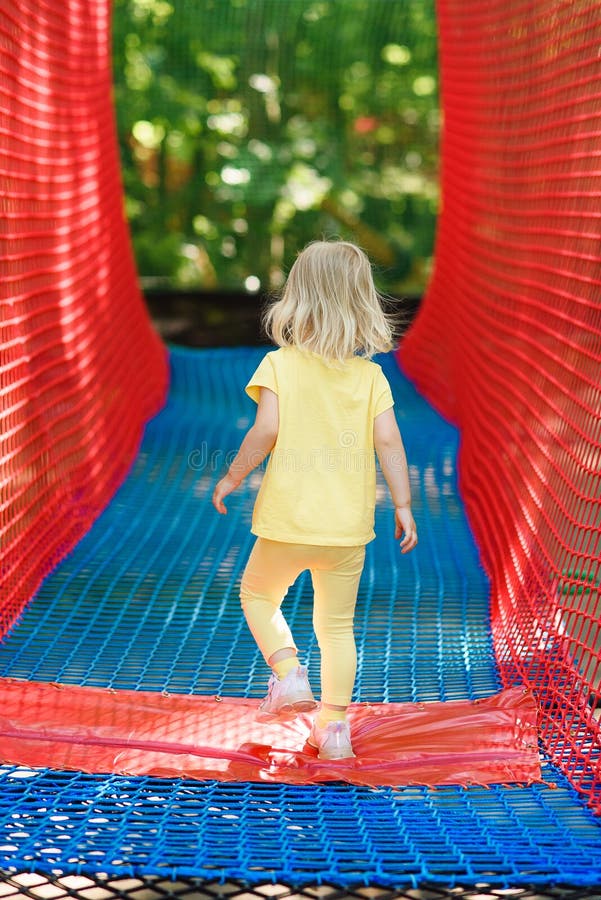 Little Girl Having Fun at a Rope Playground. the Girl is Playing on Net ...