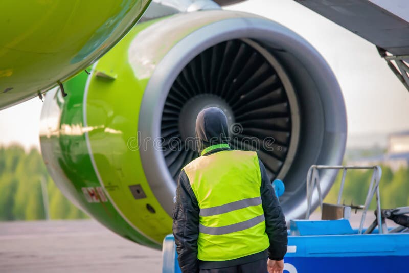 Back View of Male Pilot Standing in Front of Airplane Engine on Airport ...