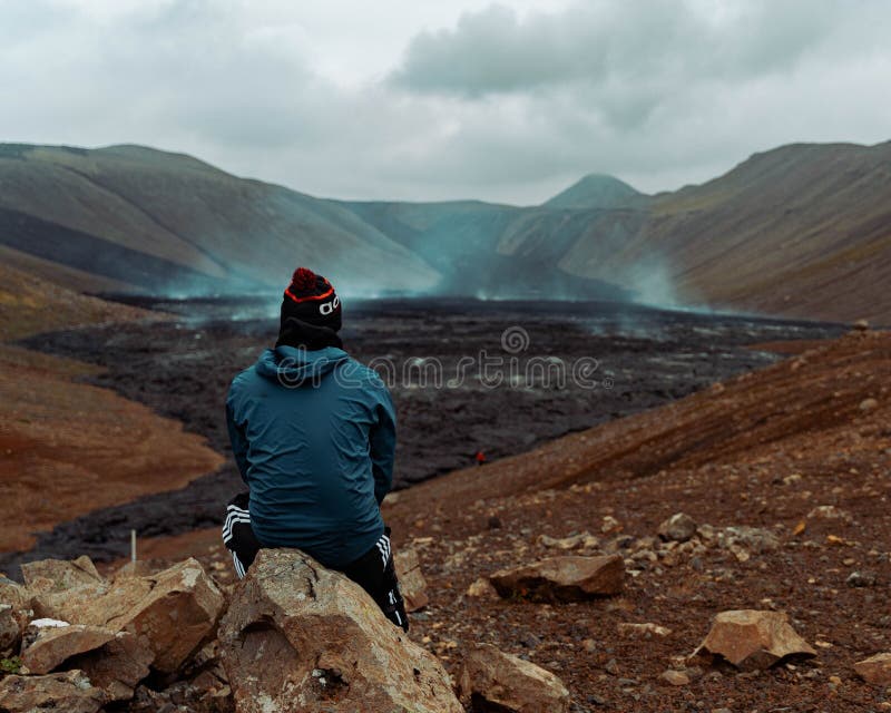 Back View of Male Sitting on Rock in Volcano Field Stock Image - Image ...