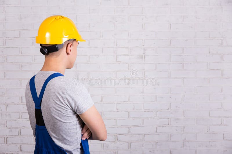Back View of Man in Blue Builder Uniform Looking at White Wall Stock ...