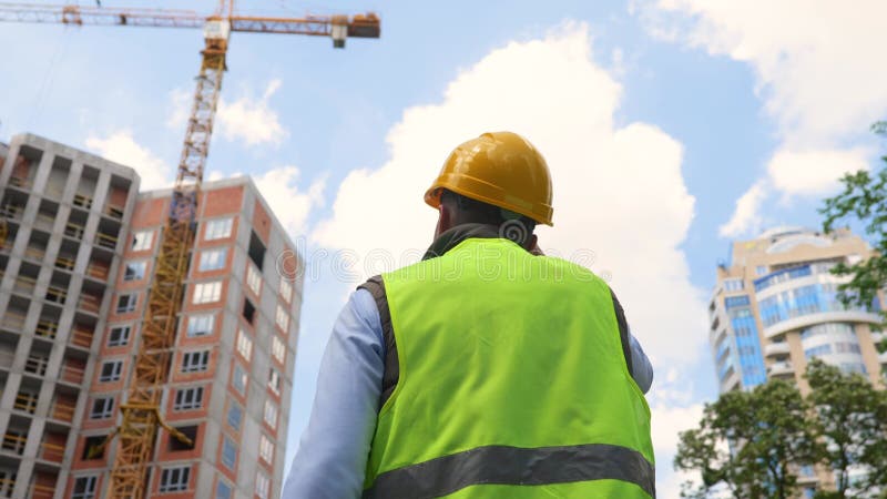 Back View of Man Builder in Uniform Standing in Front of Construction ...