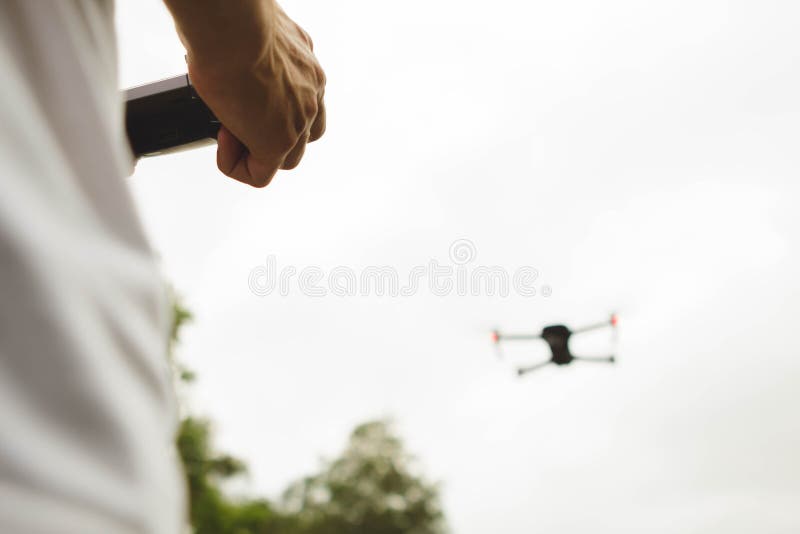 Back View of Hands Holding a Remote Control Drone Camera while Flying ...