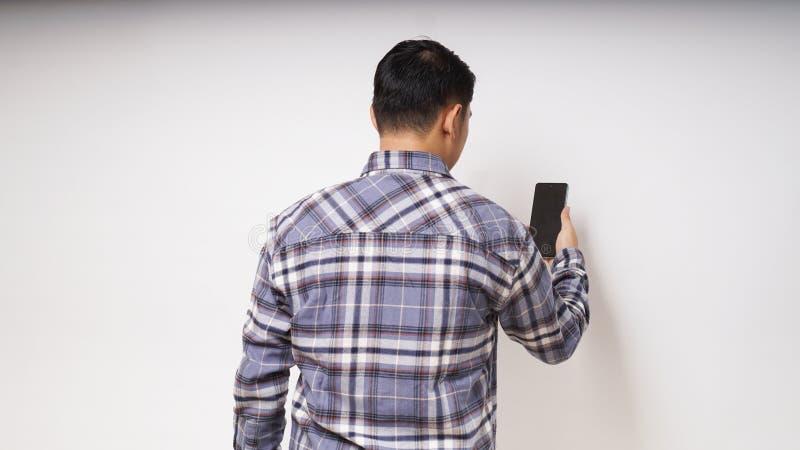 Back View of a Man Looking To the Mobile Phone that he Hold Stock Image ...