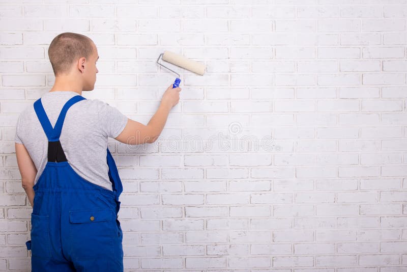 Back View of Man Painter in Workwear Painting Brick Wall with Pa Stock ...