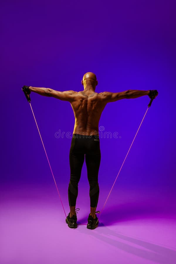 Back View of Man Performs Exercises with Expander on Studio Background ...