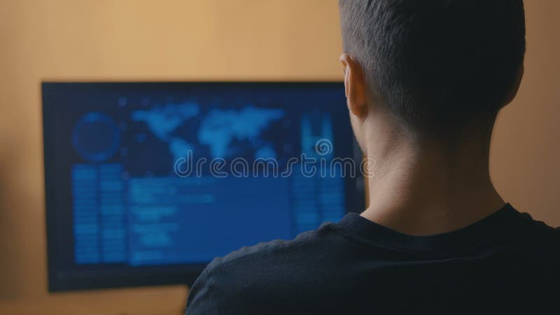 Back View Of Man Programmer Hacker Working And Drinking Coffee At Computer In The Data Center