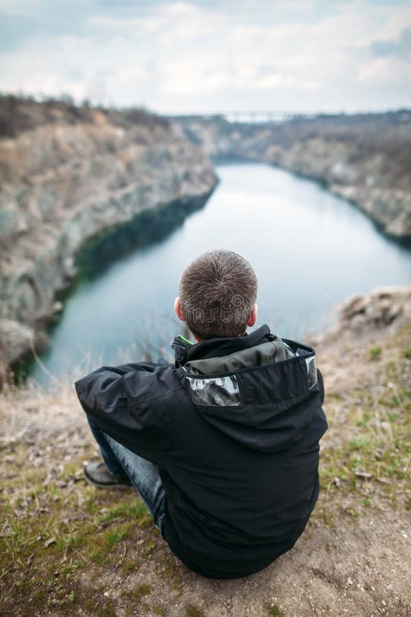 Back View of Man Relax on Rocky Cliff and Enjoying Nature Stock Photo ...