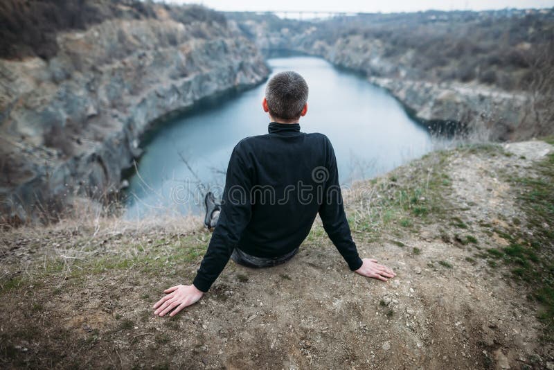 Back View Of Man Relax On Rocky Cliff And Enjoying Nature Stock Photo ...