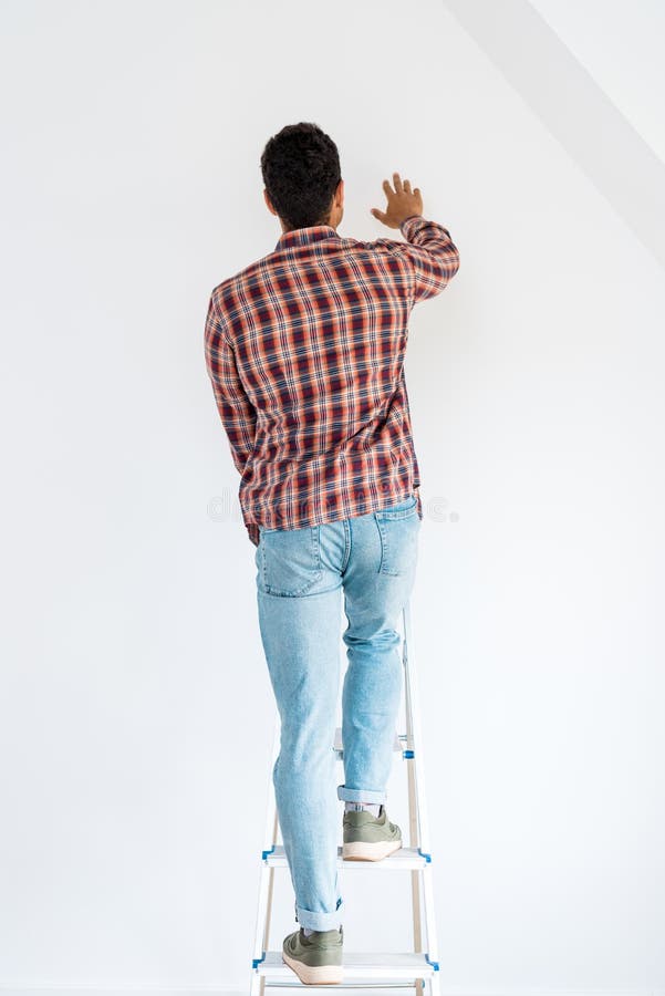 Back View of Man Standing at Ladder and Looking at Wall Stock Photo ...