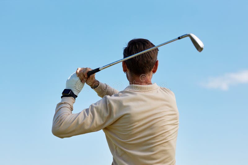 Back View of Man Swinging Golf Club Against Blue Sky Stock Image ...