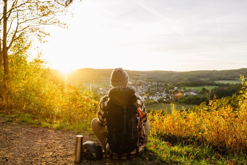 Back View of Man Tourist Enjoying Sunset View while Sitting on Hillside ...