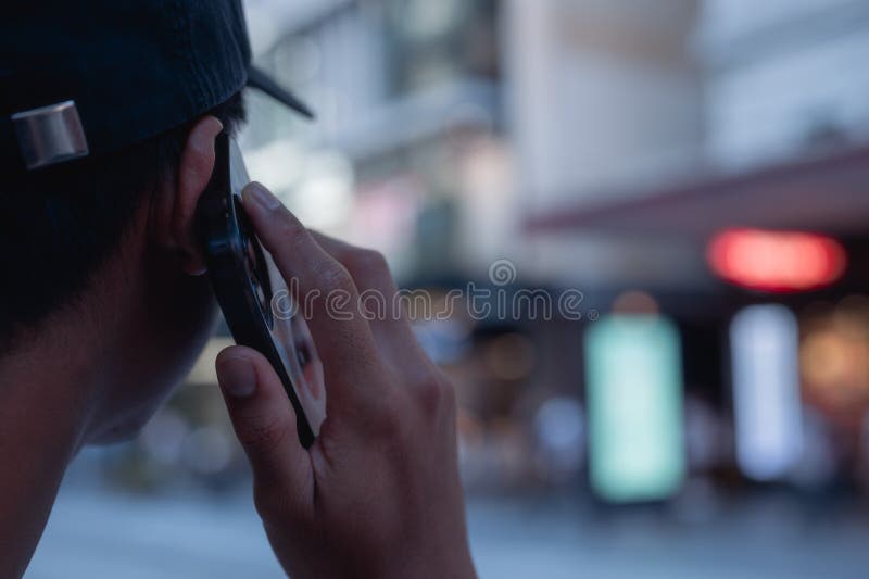 Back View of a Man Using Smart Mobile Phone Calling or Talking on the ...
