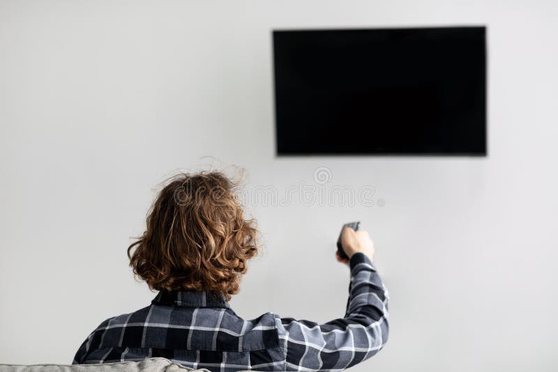 Back-View of Man Watching TV Sitting on Couch at Home Stock Photo ...