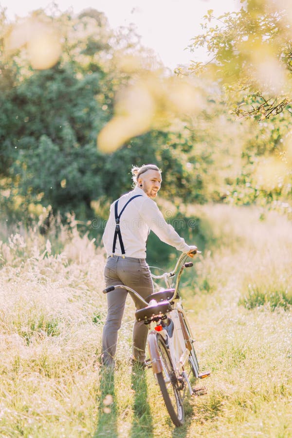 The Back View of the Modern-dressed Groom Holding the Bicycle in the ...