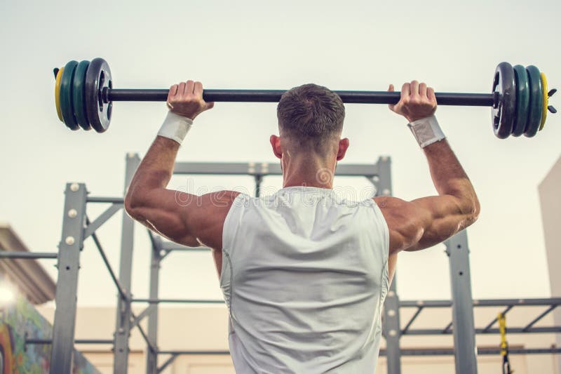 Back View of Muscular Man Lifting Barbells Outdoors Stock Photo - Image ...