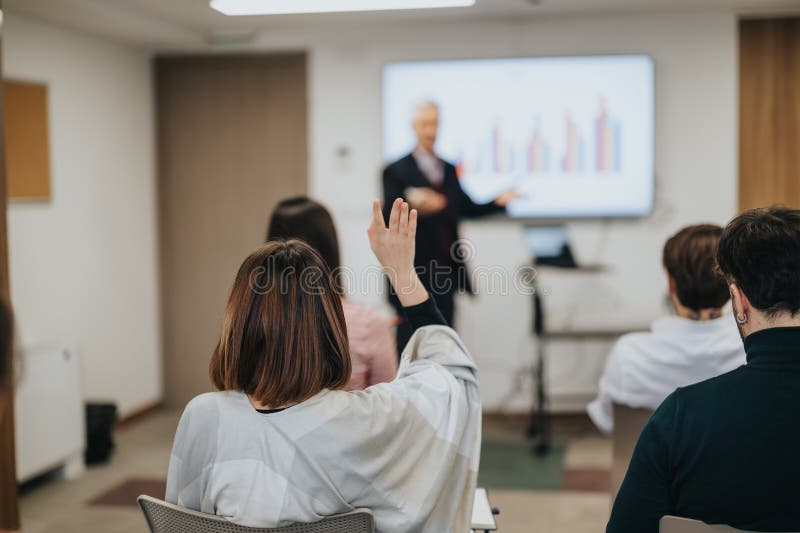 Back View of Participants Raising Hands in an Interactive Session at a ...