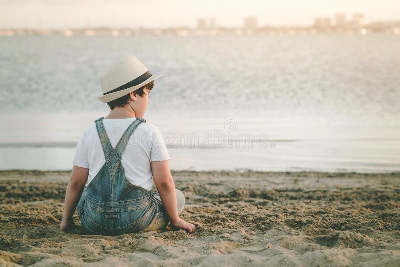 Back View of a Pensive Child Sitting on the Beach Stock Image - Image ...