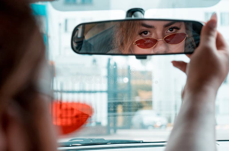 Non-binary Young Driving a Car Looking in the Rear View Mirror Stock ...