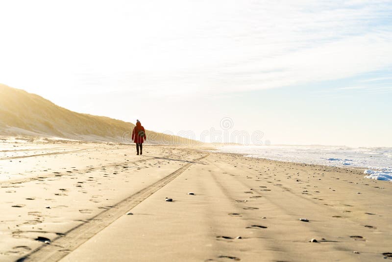 Back View of a Person in a Red Coast on an Idyllic Sandy Beach in ...