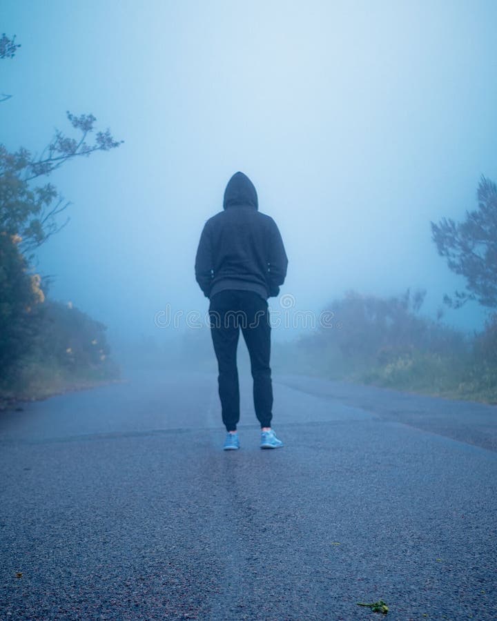 Back View of a Person Standing on an Empty Road with Fog Stock Photo ...