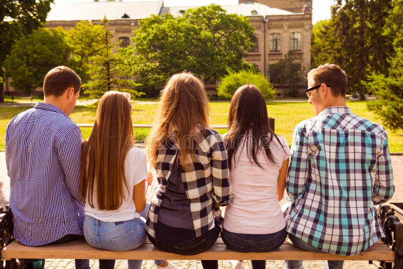 Back View Photo of Five Diverse Students Sitting on Bench and Study Up ...