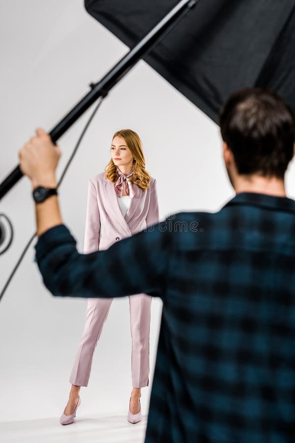 Back View of Photographer Working with Lighting Equipment while Female ...