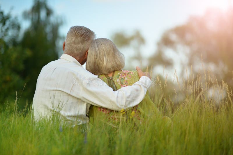 Back View of Senior Couple Sitting on Grass Stock Photo - Image of ...