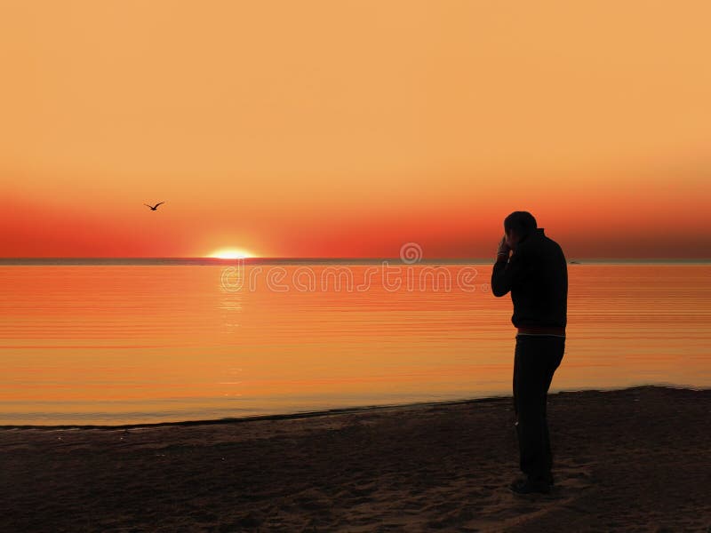 Back View of a Silhouette of a Man Photographing the Sun at Sunset on ...