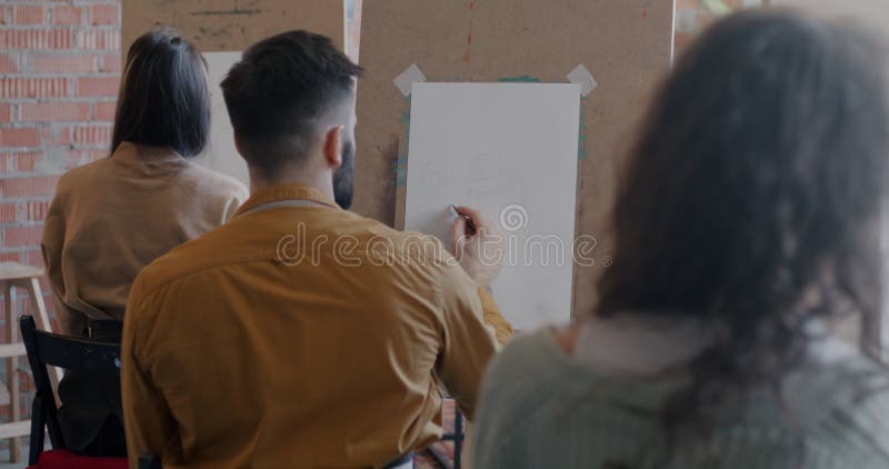 Back View of Students Male and Female Drawing Learning Together during ...